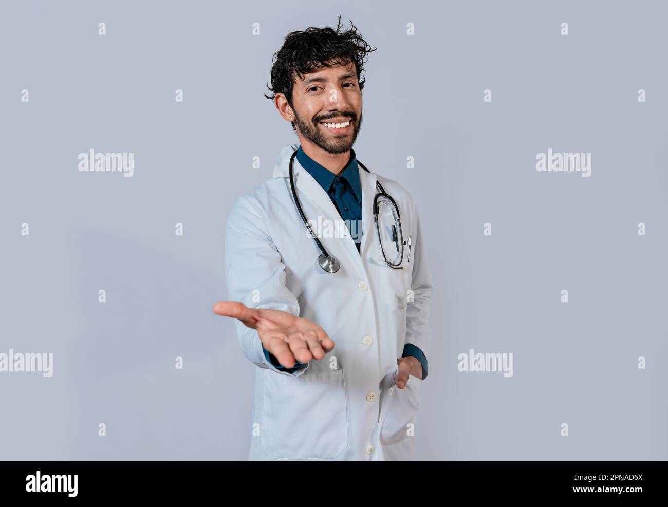 Smiling doctor extending hand in welcome. Young doctor extending hand ...