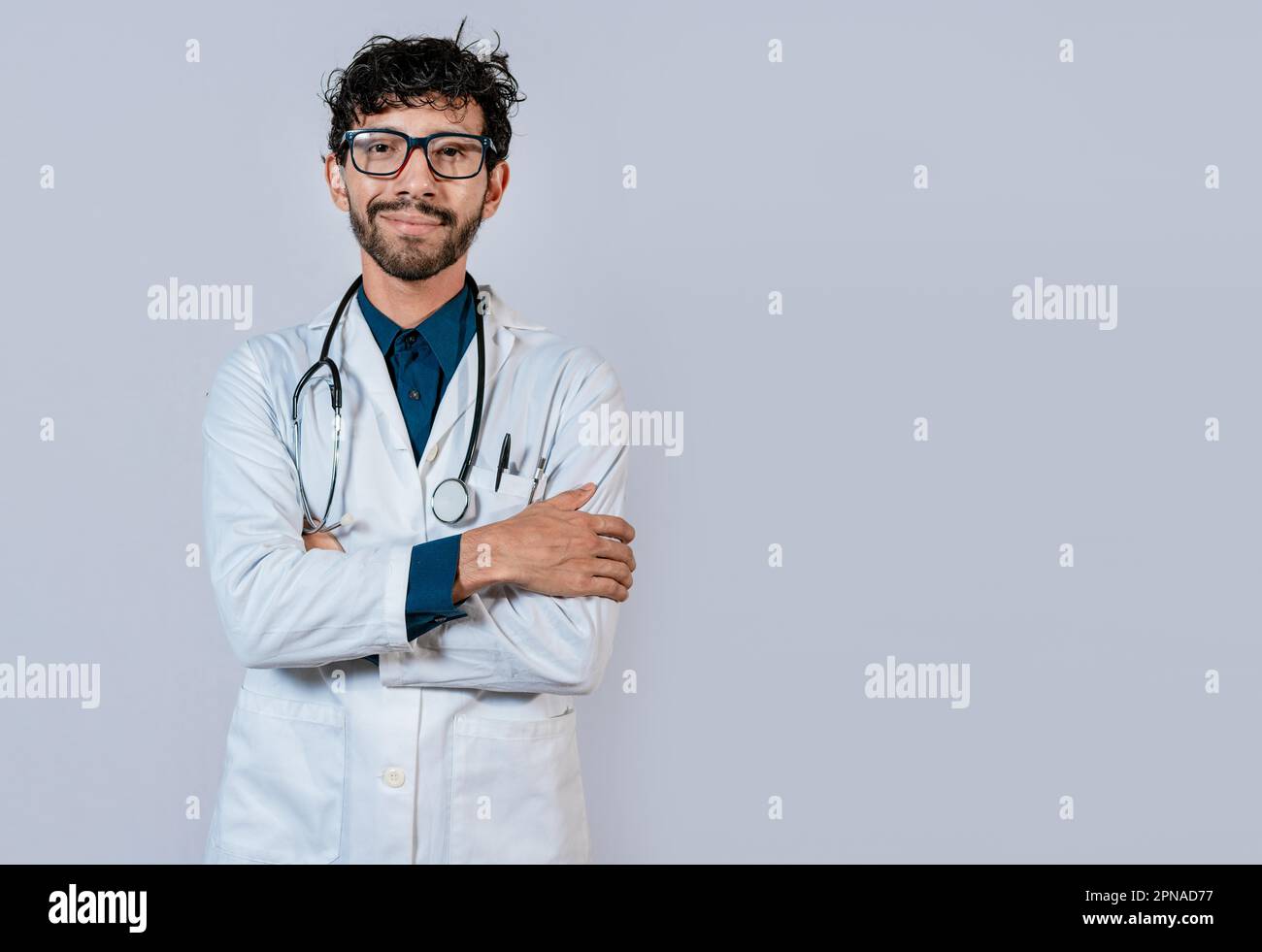 Portrait of young doctor with arms crossed. Smiling doctor with crossed ...
