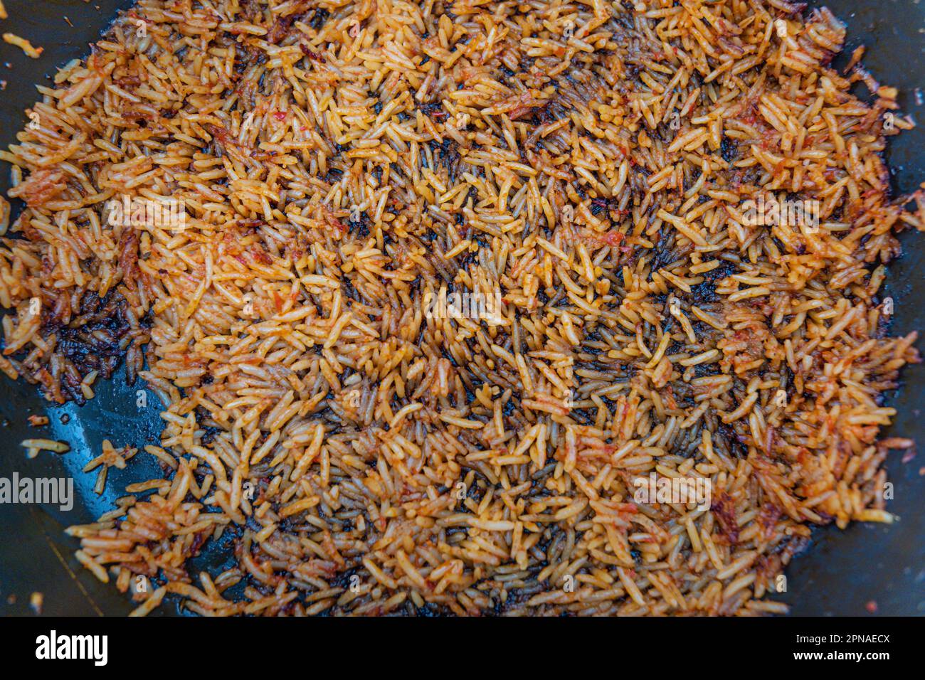 Burnt Nigerian smoky Jollof at the bottom of a pot Stock Photo - Alamy