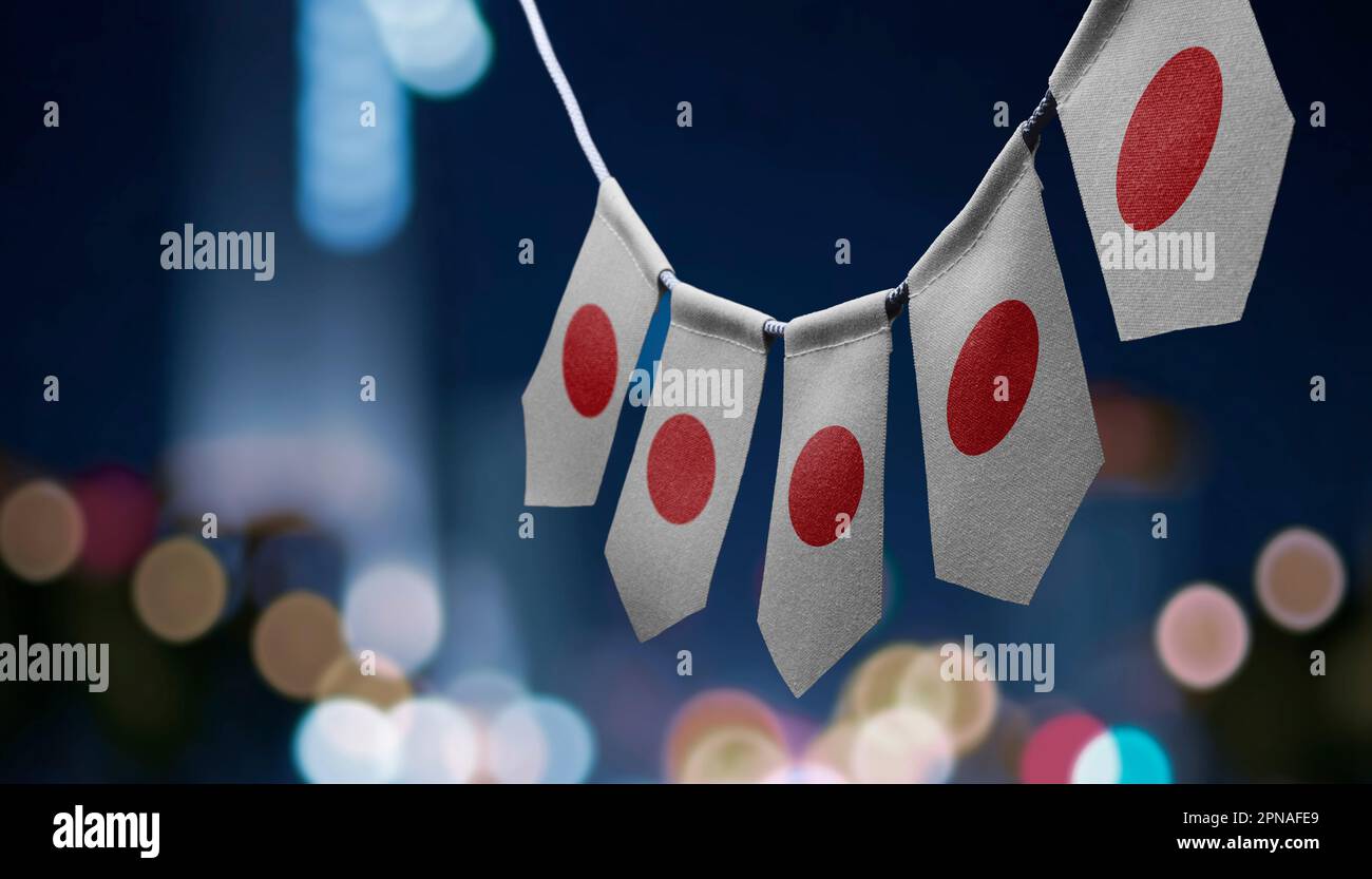 A garland of Japan national flags on an abstract blurred background ...