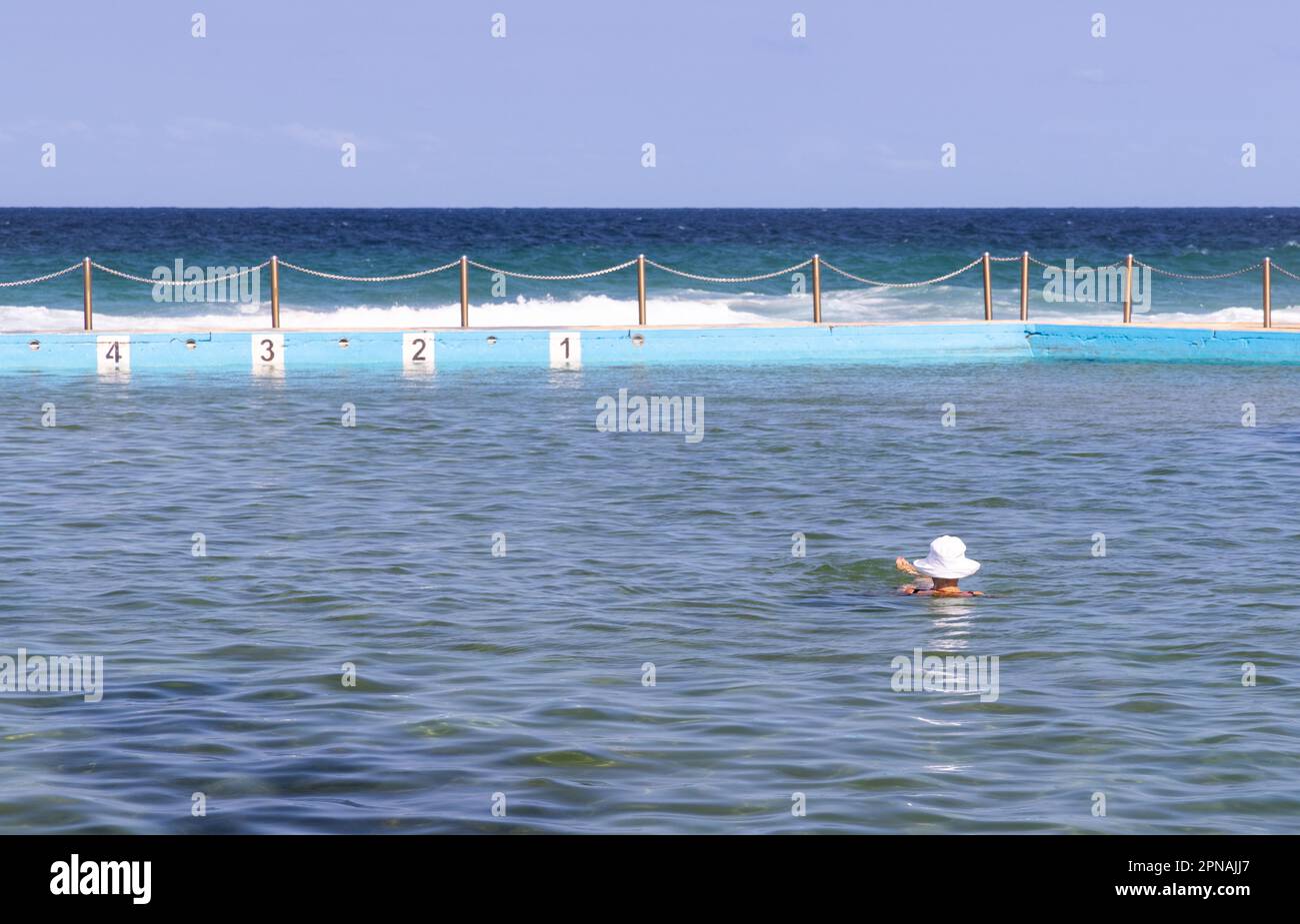 South Curl Curl rock pools, ocean swimming pools. Lone swimmer in a ...