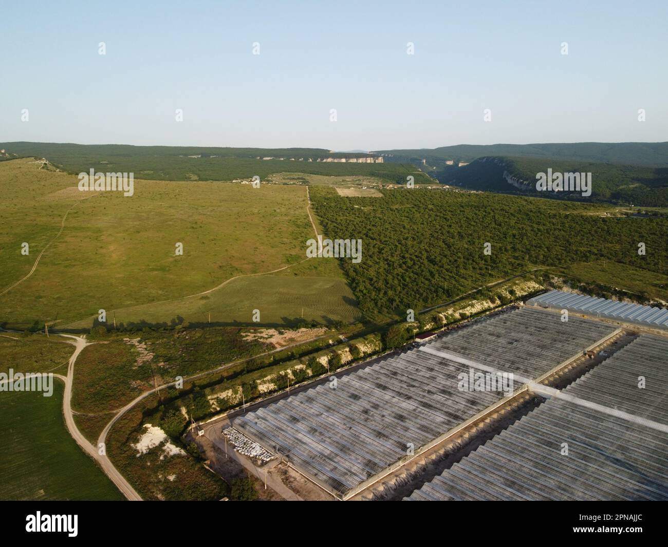 Aerial view on greenhouse factory surrounded by wheat field in ...