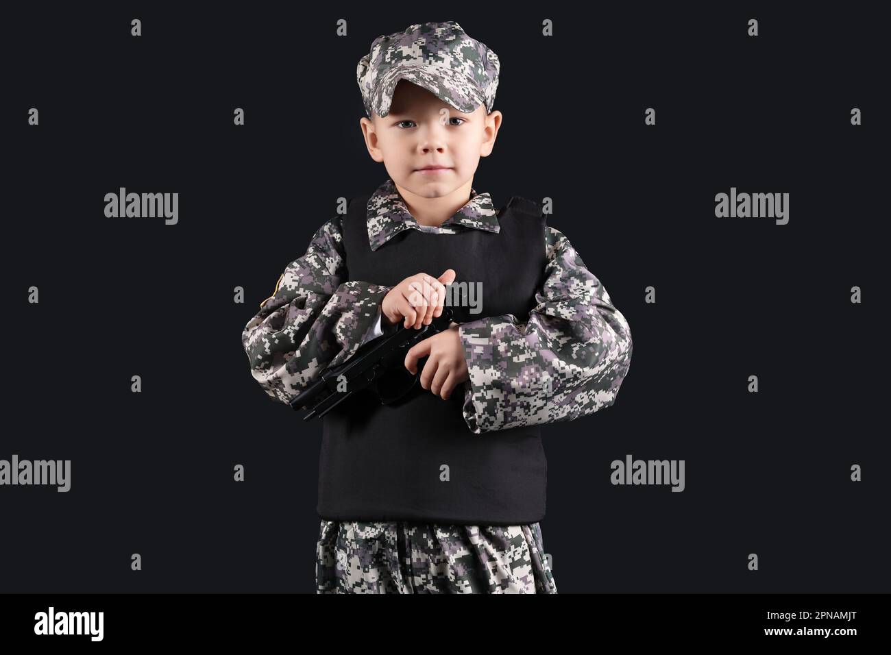 Cute little soldier with gun on black background Stock Photo - Alamy