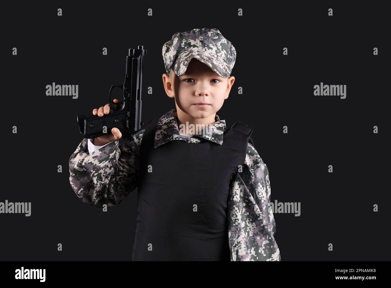 Cute little soldier with gun on black background Stock Photo - Alamy