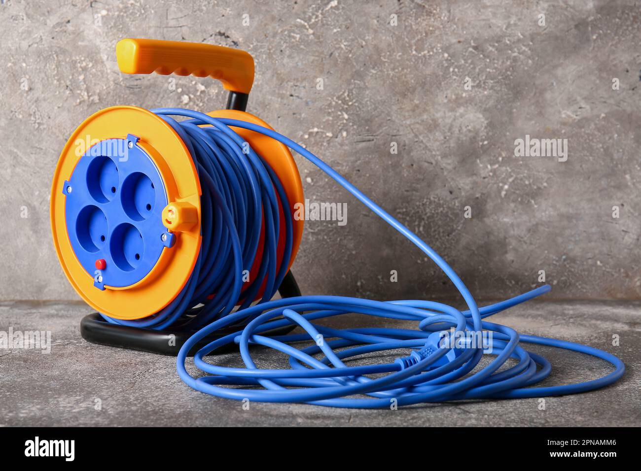 Extension electric cable reel on grunge background Stock Photo - Alamy
