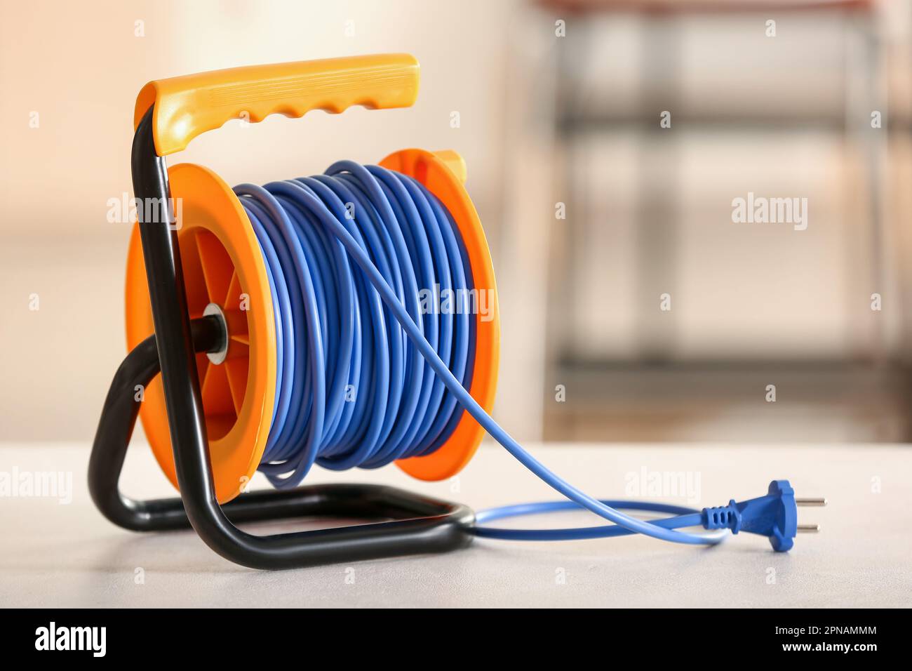 Extension electric cable reel on table Stock Photo - Alamy