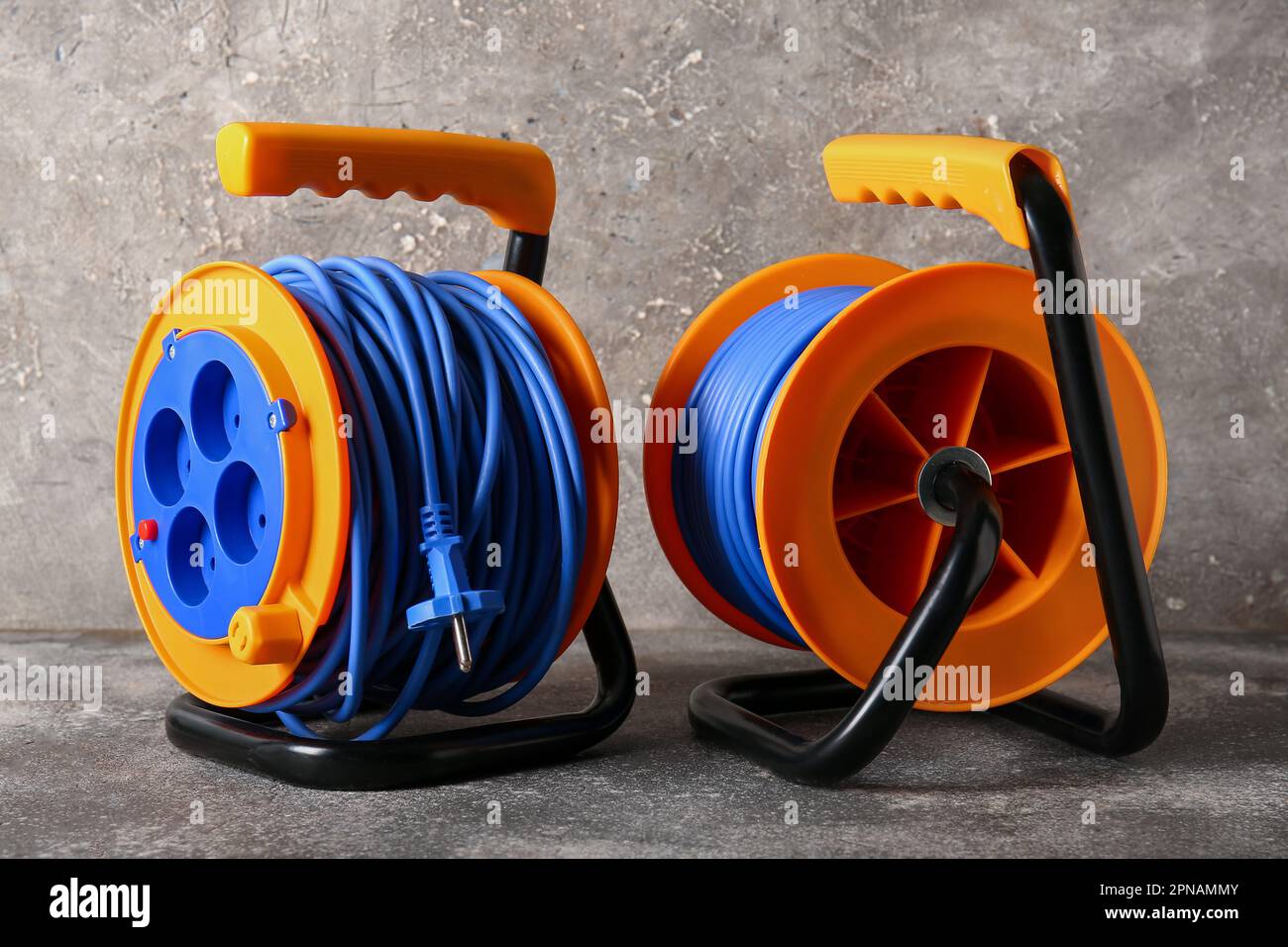 Extension electric cable reels on grunge background Stock Photo - Alamy