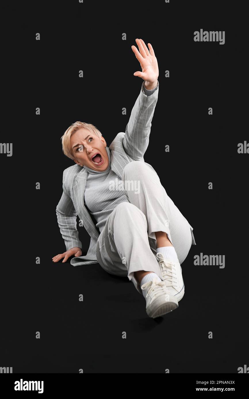 Scared mature woman on black background Stock Photo - Alamy