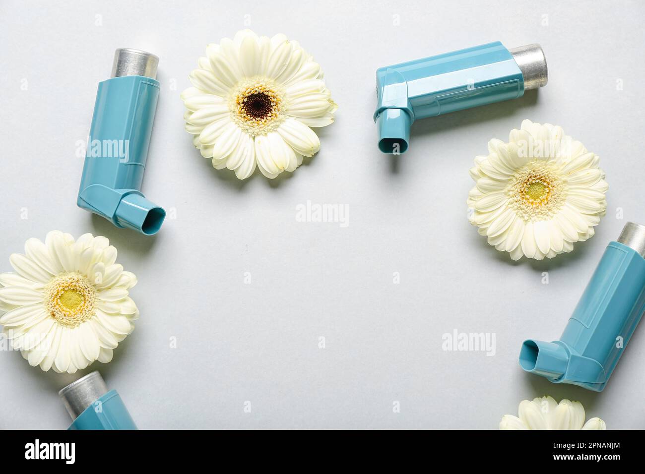 Frame made of inhaler with flowers on grey background Stock Photo - Alamy