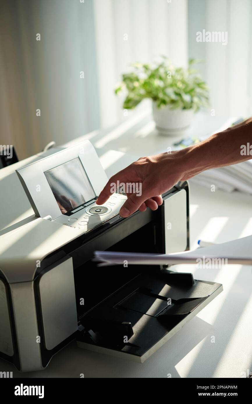 Businessman putting paper sheet in printer to print documents for ...