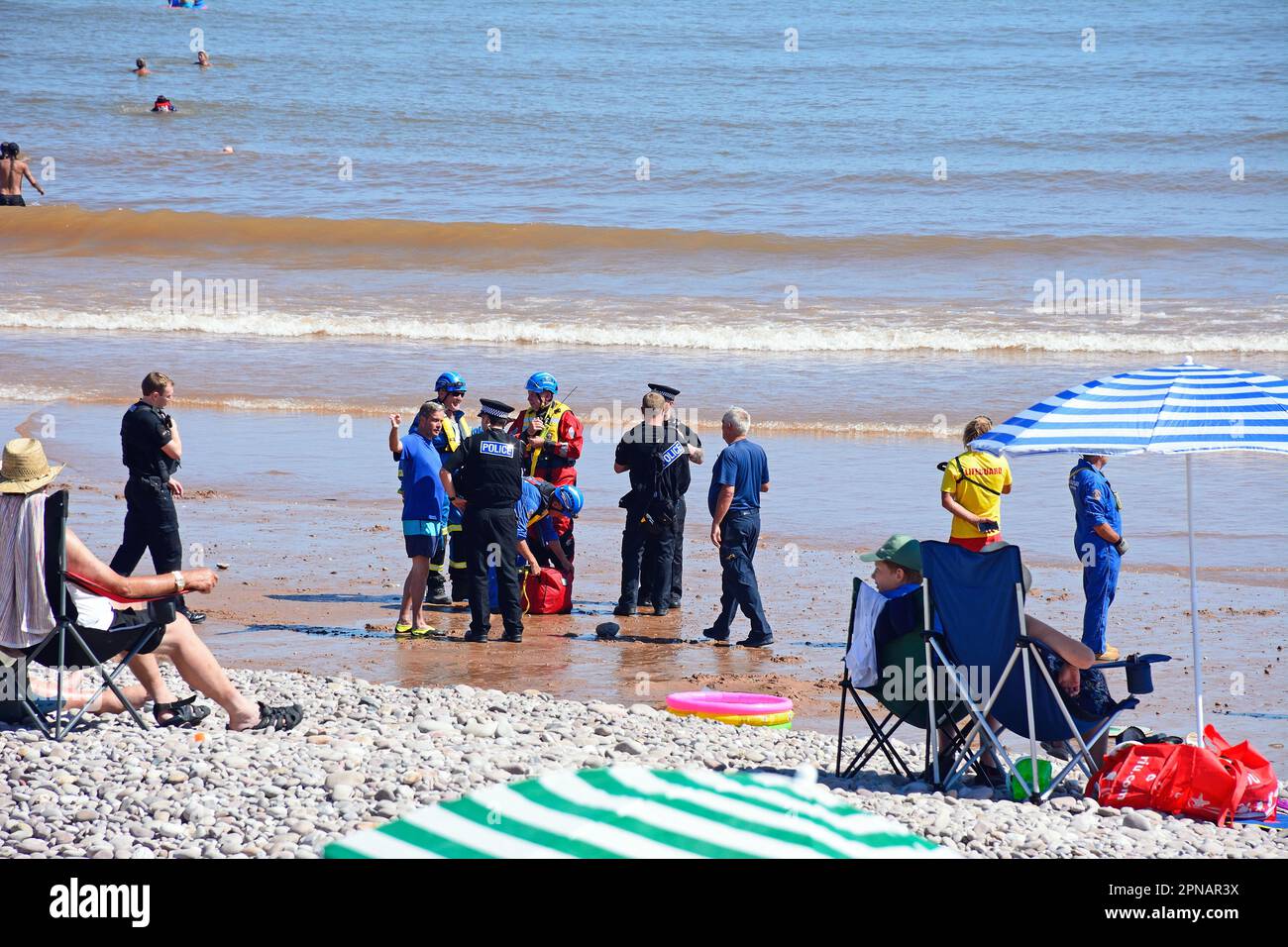 Police officers along with search and rescue standing on the beach ...