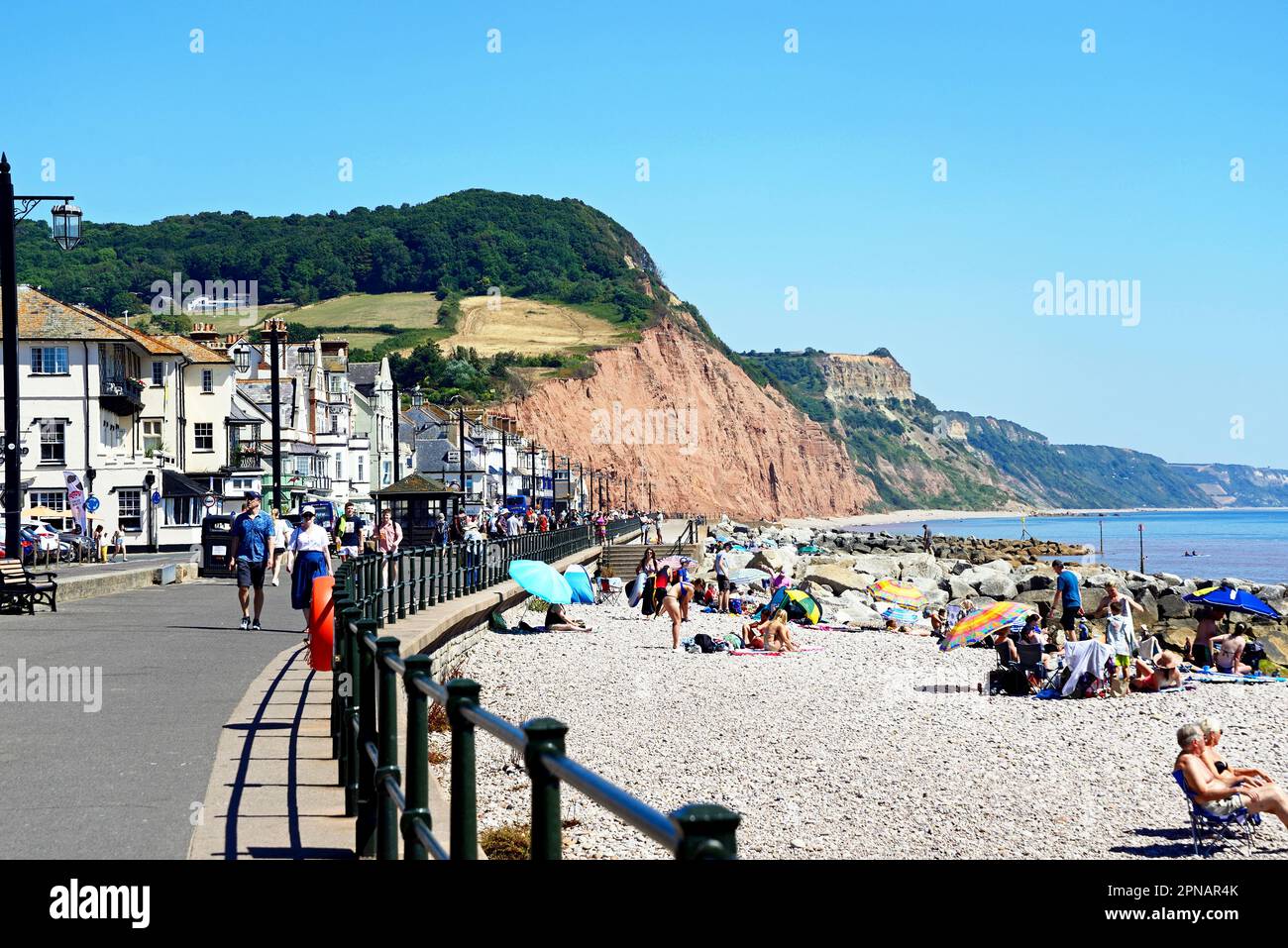 Tourists relaxing on the beach with views towards town buildings and ...