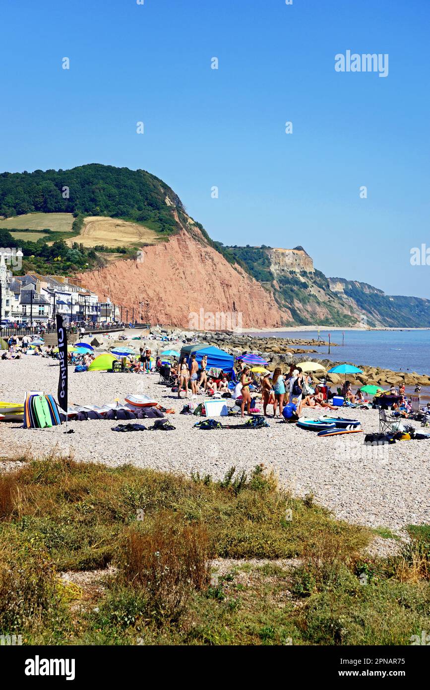 Tourists relaxing on the beach with views towards town buildings and ...