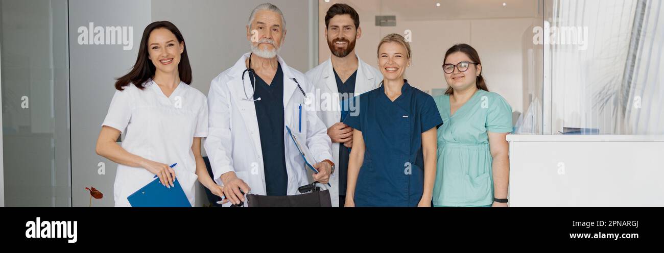Group of professional doctors in uniform standing in clinic hall with ...