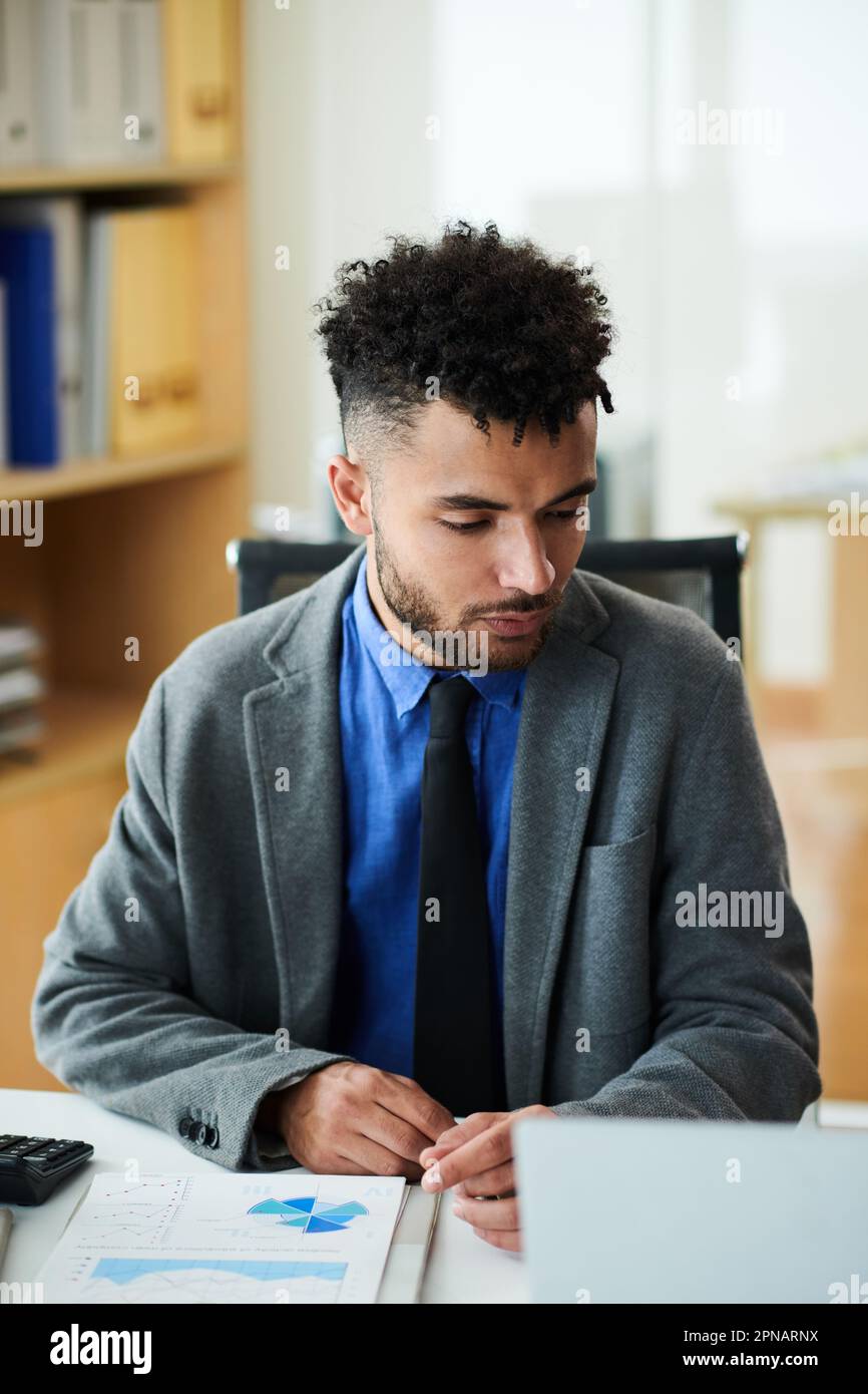 Young entrepreneur working with documents at office desk Stock Photo ...