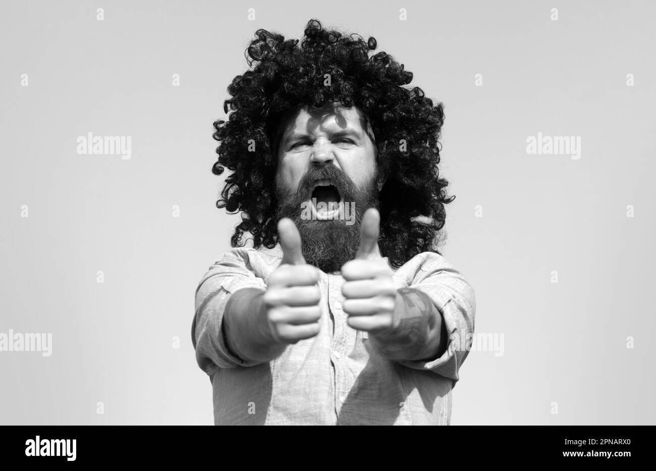 Funny nerdy guy with thumbs up. Crazy funny bearded man with wig on sky ...