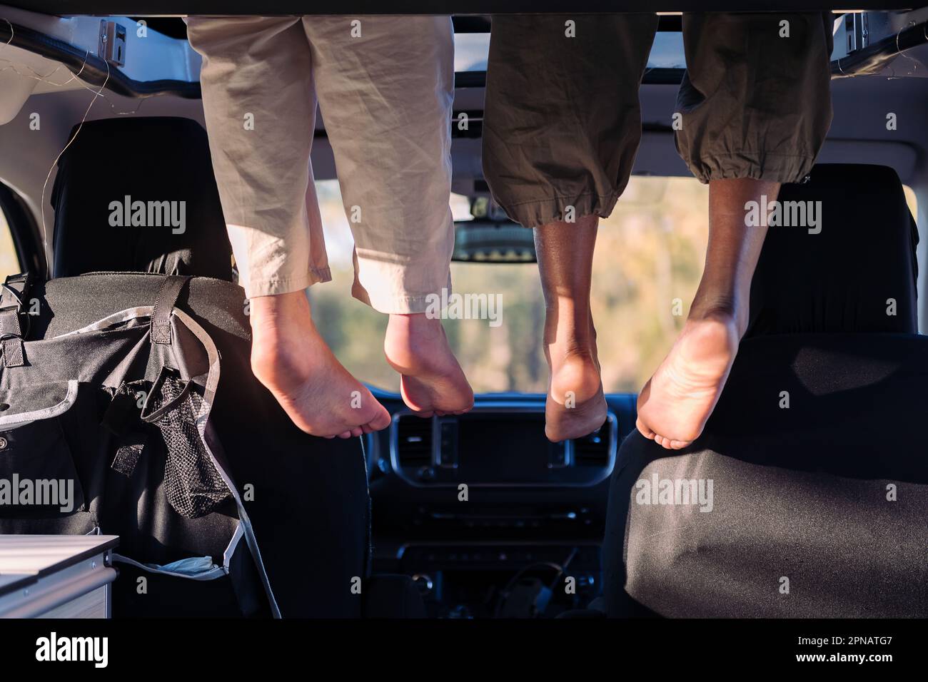 feet dangling off the elevated bed of a camper van Stock Photo - Alamy