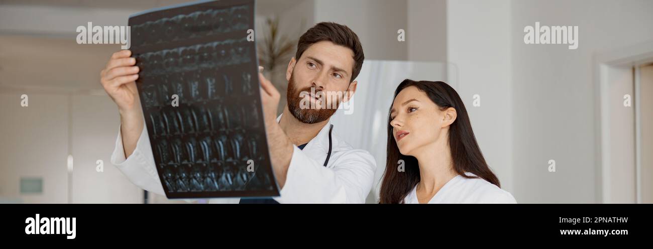 Two doctors in uniform look and discuss an X Ray or MRI scan of the ...