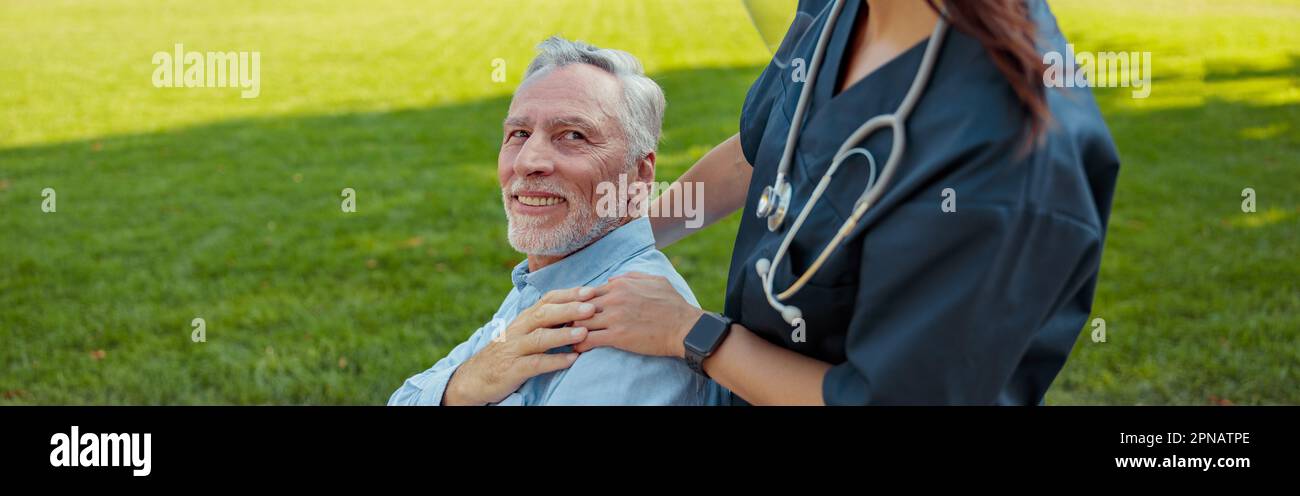 Caring nurse wearing face shield and mask on a walk with aged man ...