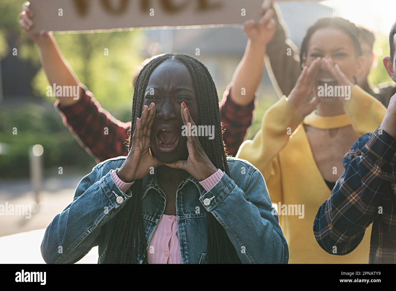 African woman with dreadlocks shouting during a protest in a city ...