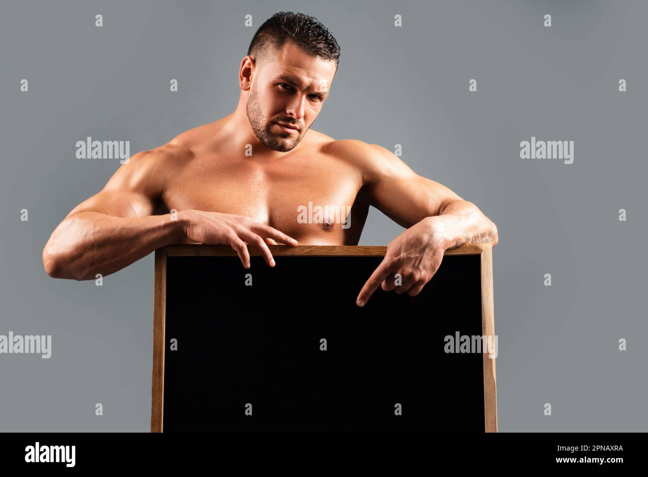 Handsome bodybuilder man with sign advertising board. Strong muscular ...