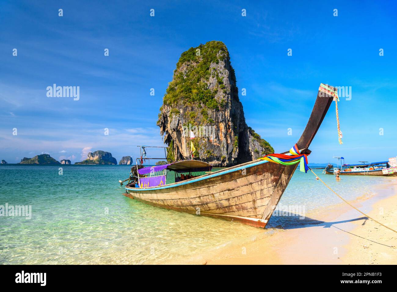 Long tail boats and cliff rock in azure water, Ko Rang Nok, Ao Phra ...