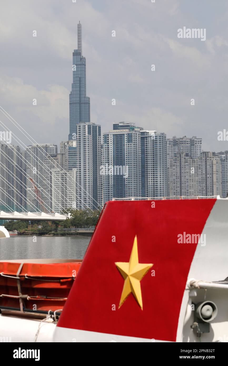 Vietnamese red flag on a ferry boat. Landmark 81, the tallest ...