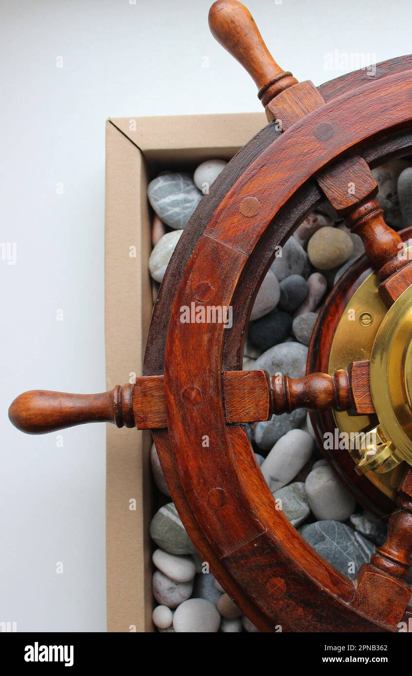 Box With Sea Pebble Stones Under Wooden Ship Steering Wheel Stock Photo ...