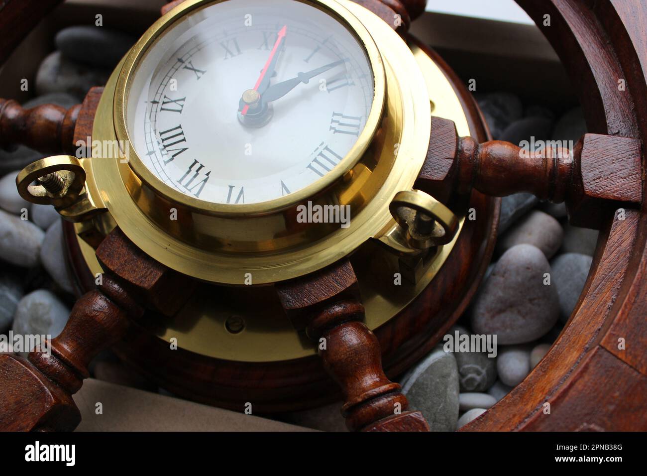 Vintage clock in the center of a round wooden frame over sea stones ...