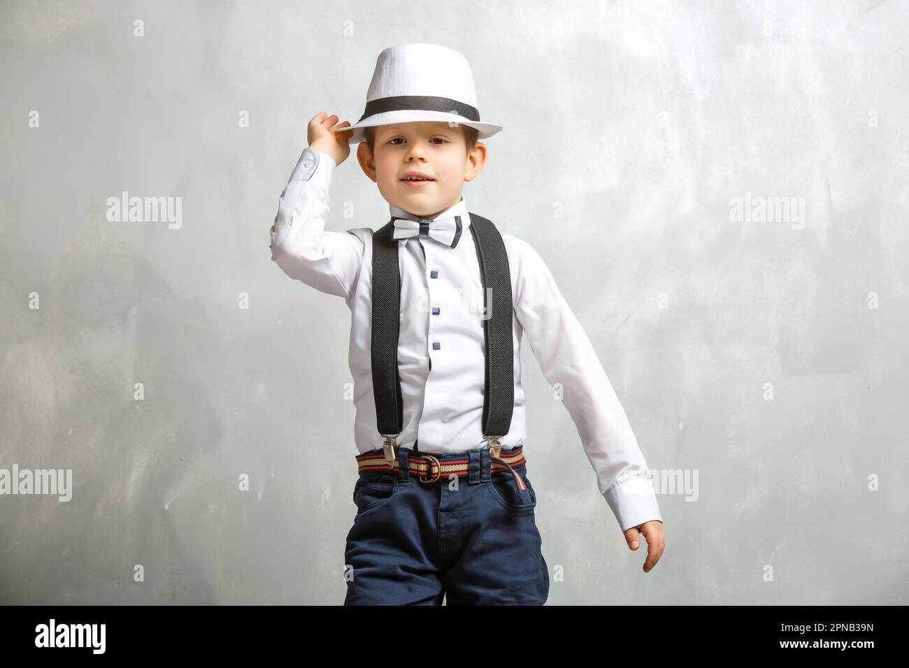 Elementary school student carrying notebooks over a gray background ...