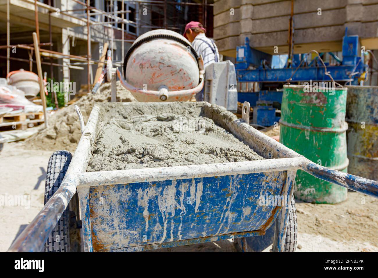 Unloaded fresh mortar from cement mixer machine into mason's cart, full ...