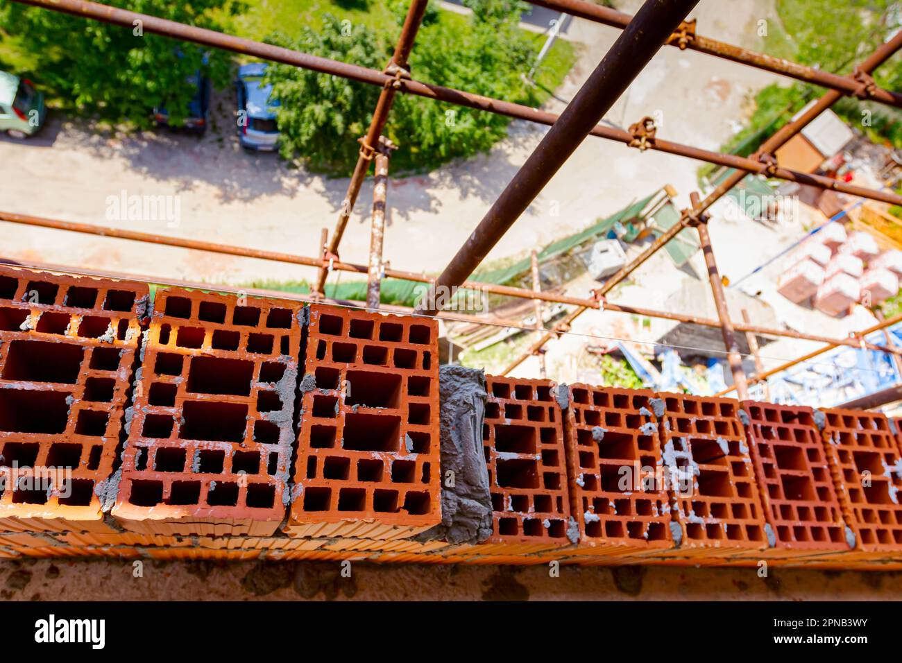 Wall edge made of red blocks and mortar with rusty scaffold on ...