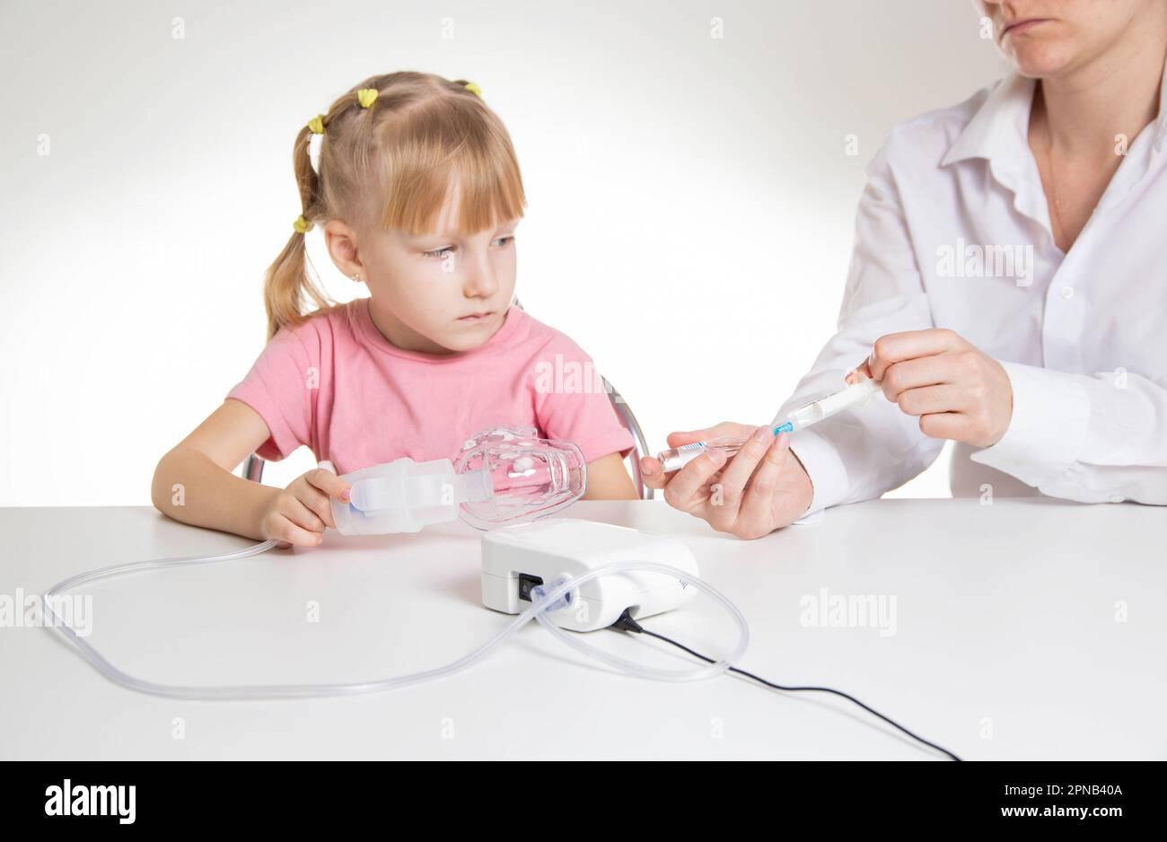 A doctor is putting a drug into a nebulizer for the treatment of ...