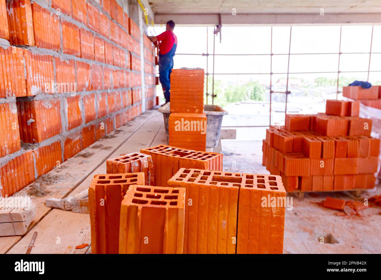 Heap of red ceramic blocks placed on wood platform on construction site ...