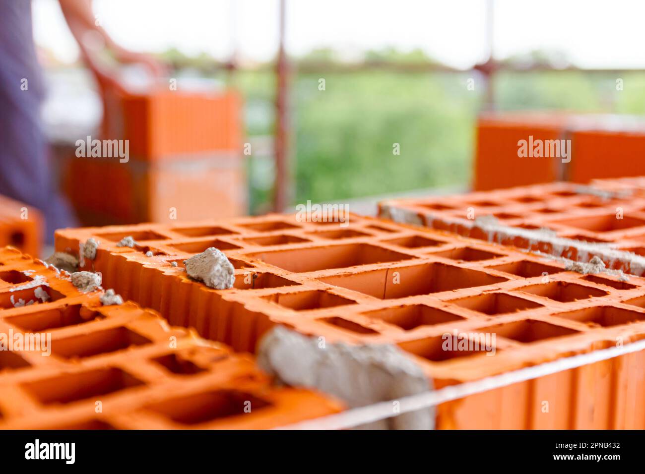 Bricklaying wall with red blocks and mortar, tighten rope placed for ...