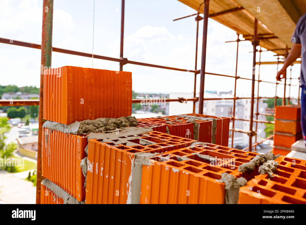 Wall edge made of red blocks and mortar with rusty scaffold on ...