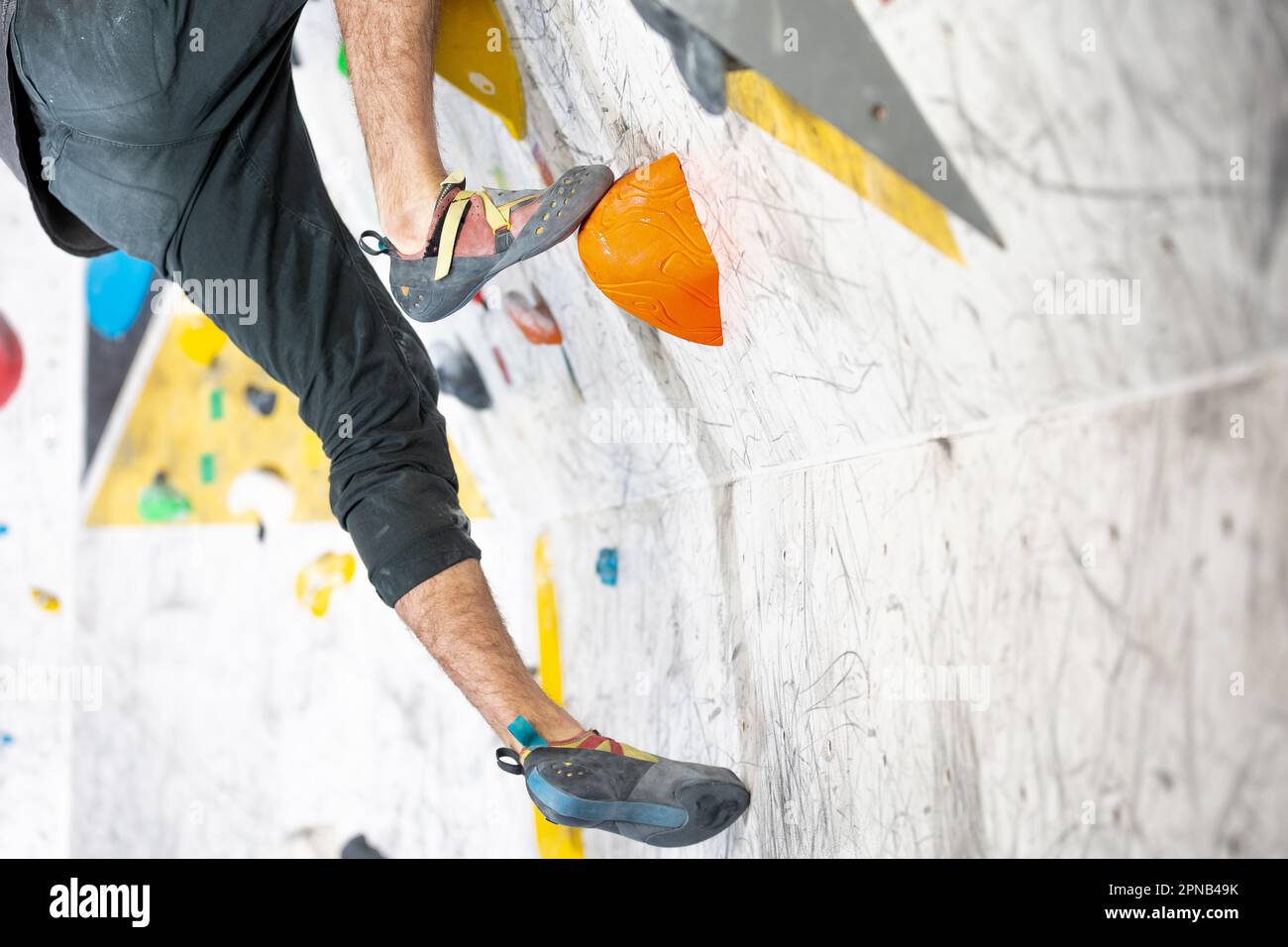 Young climber climbing on the boulder wall indoor, rear view, concept ...