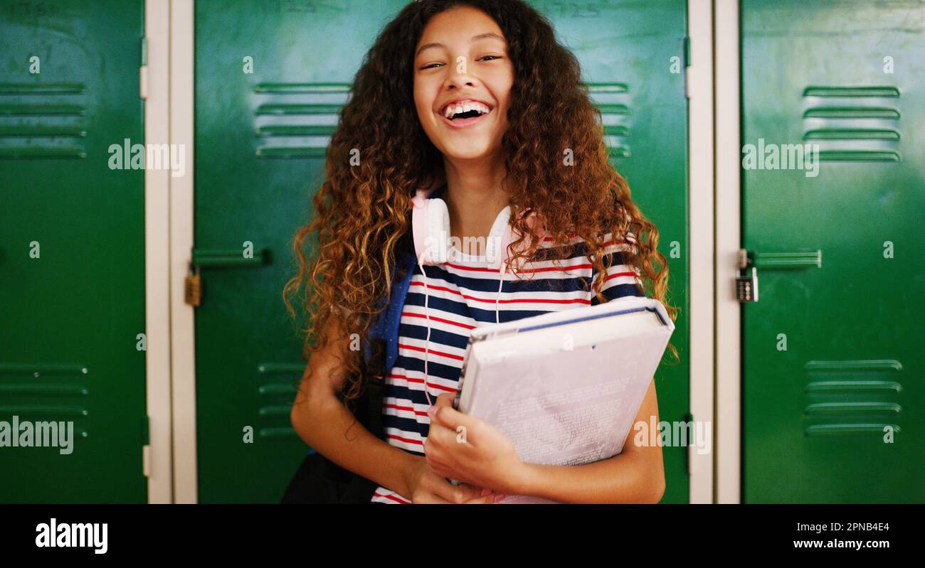Cheerful and ready to hit the books. a cheerful young school kid holding her books while waiting ...