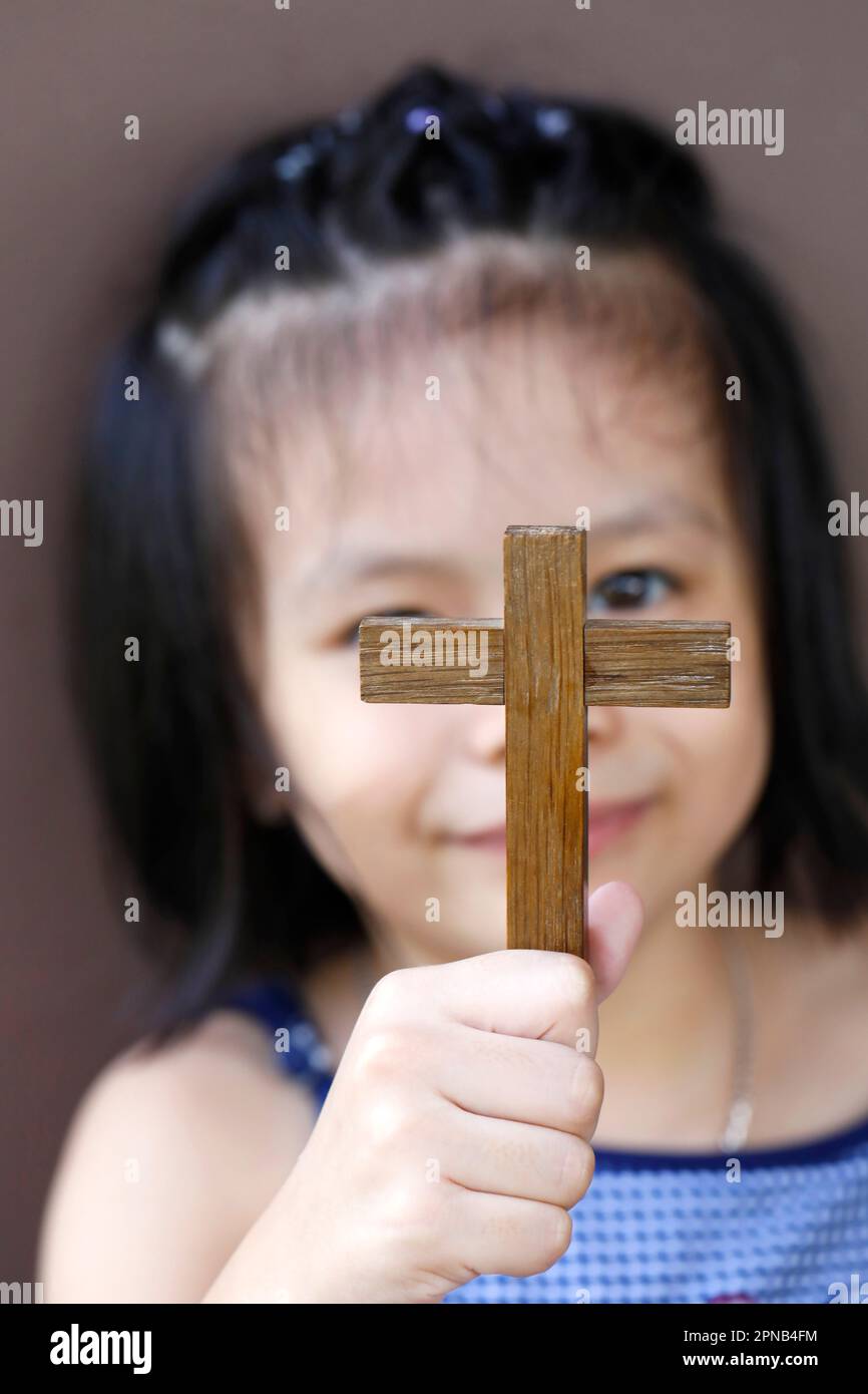 Teenage girl praying to God holding a wooden cross. Concept of hope ...