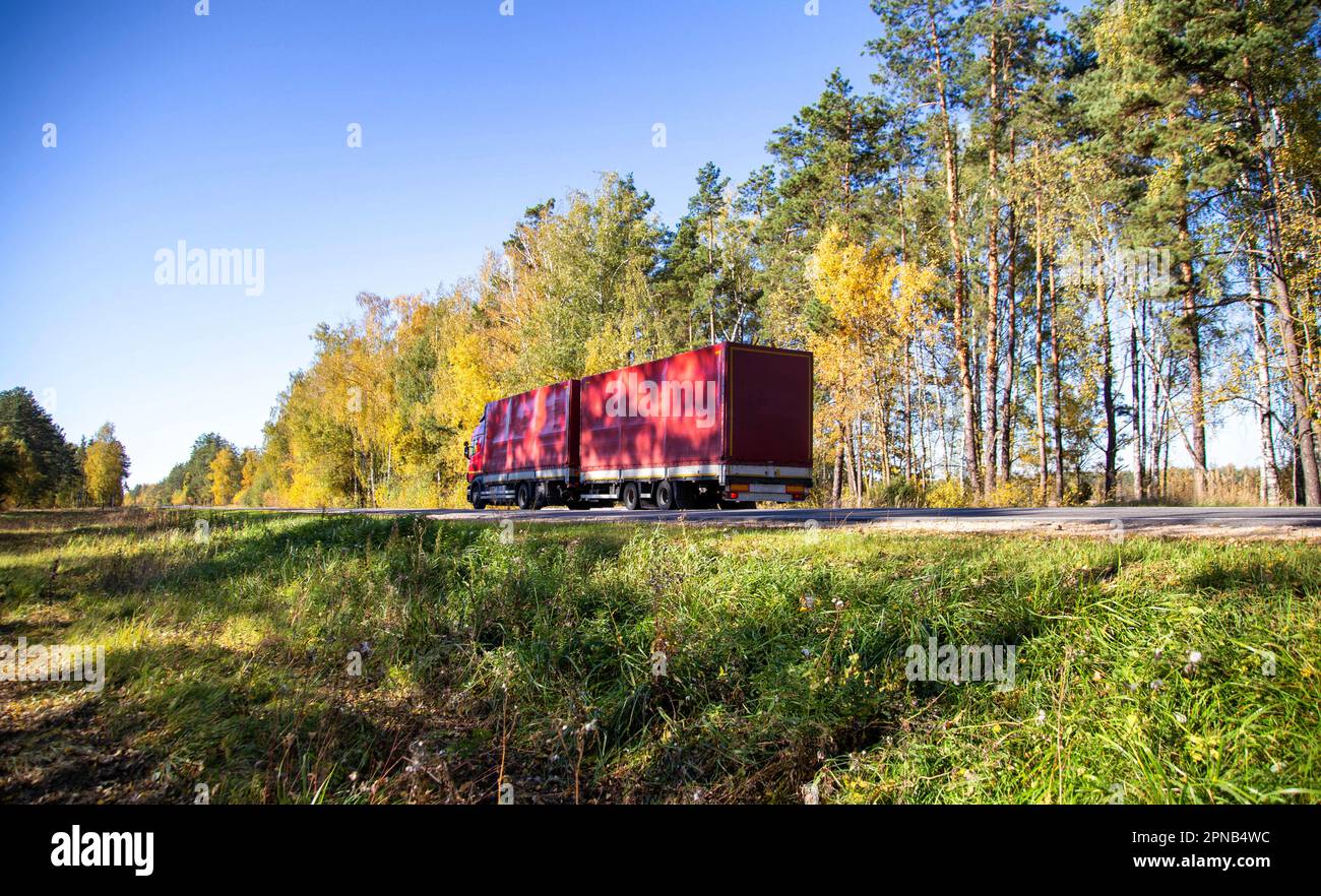 The new red truck with a semi-trailer transports a lot of bulk cargo ...