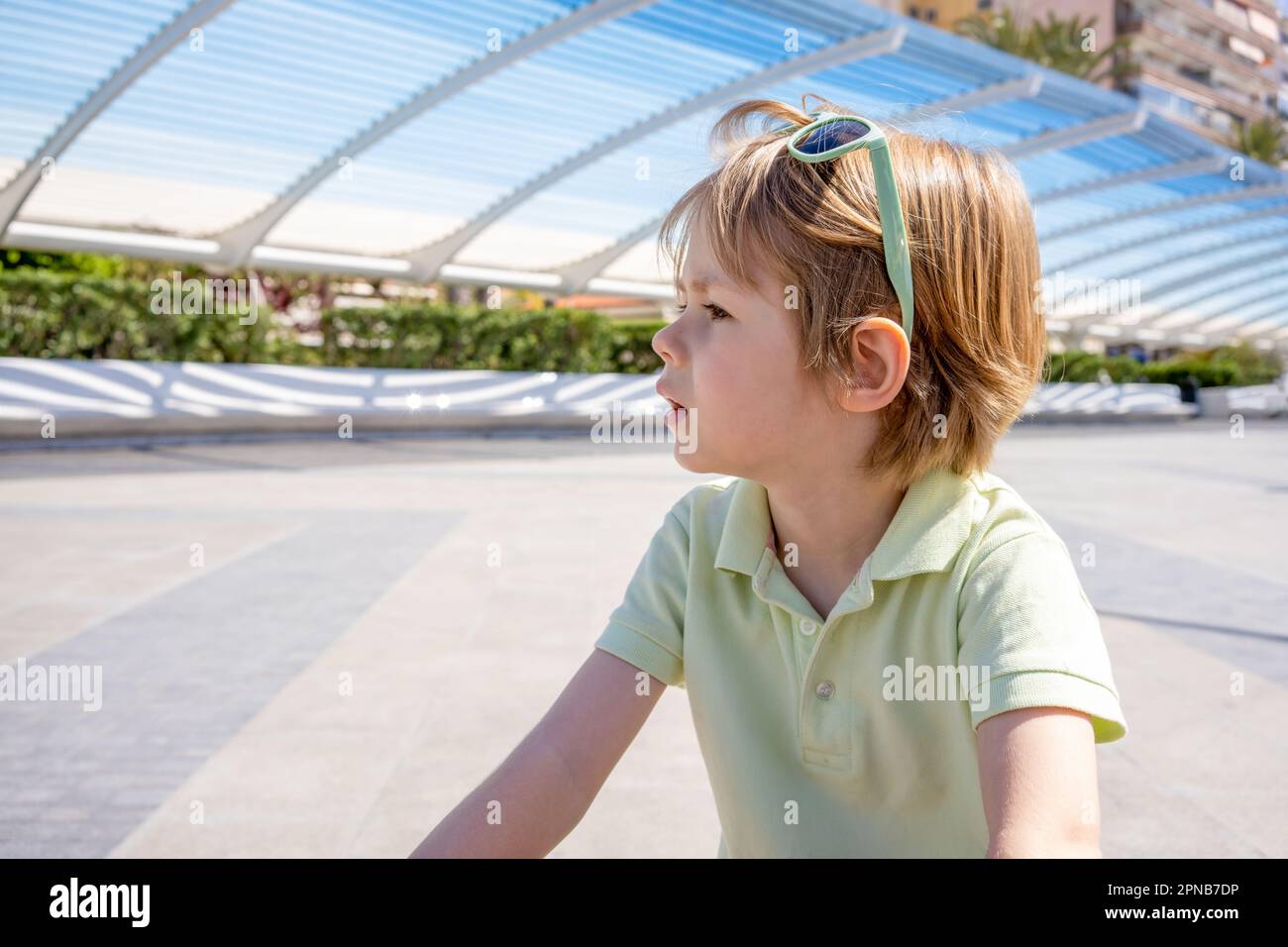 side view of a blonde little boy in a park outdoors Stock Photo - Alamy