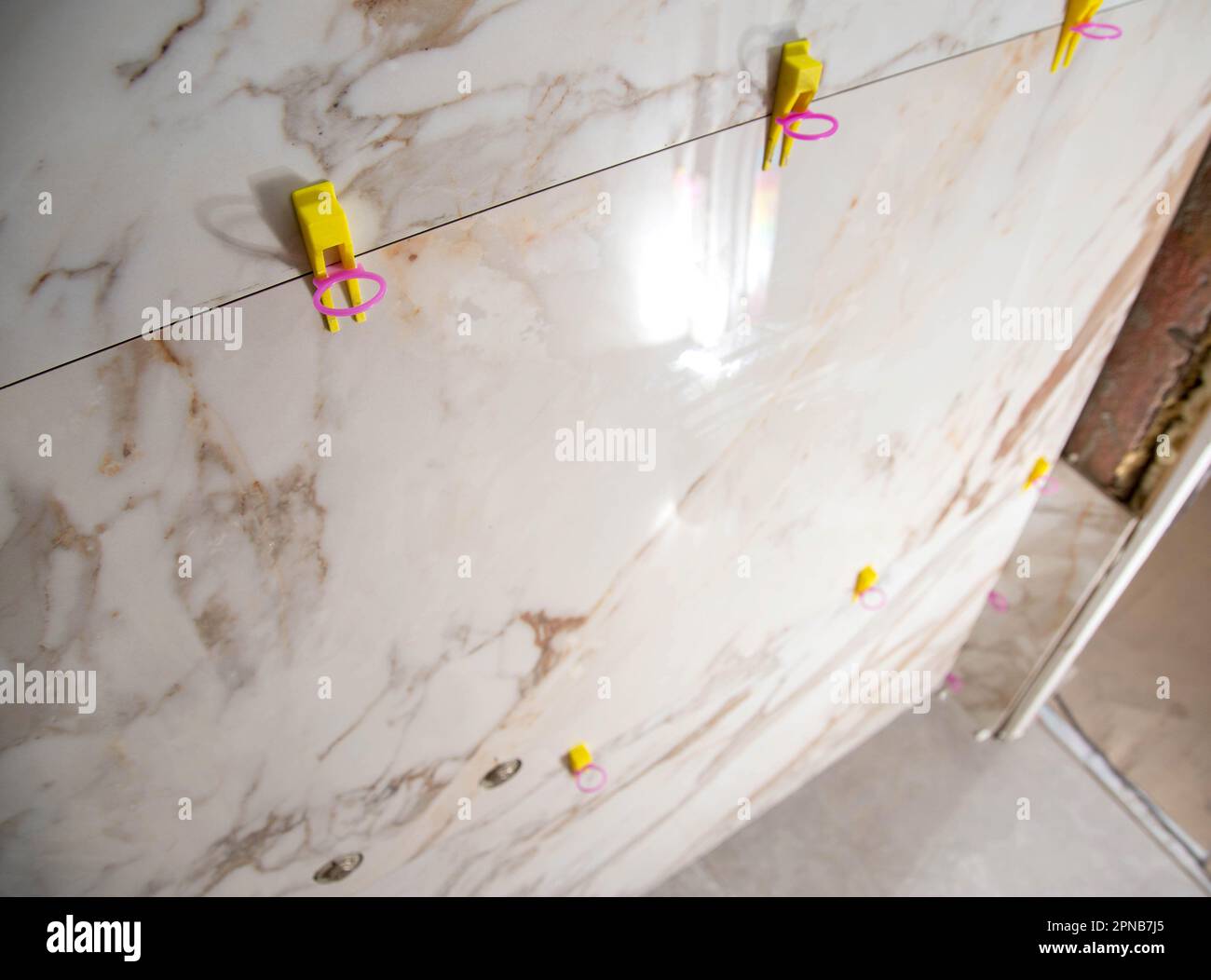 Laying porcelain stoneware tiles on a tile leveling system Stock Photo ...