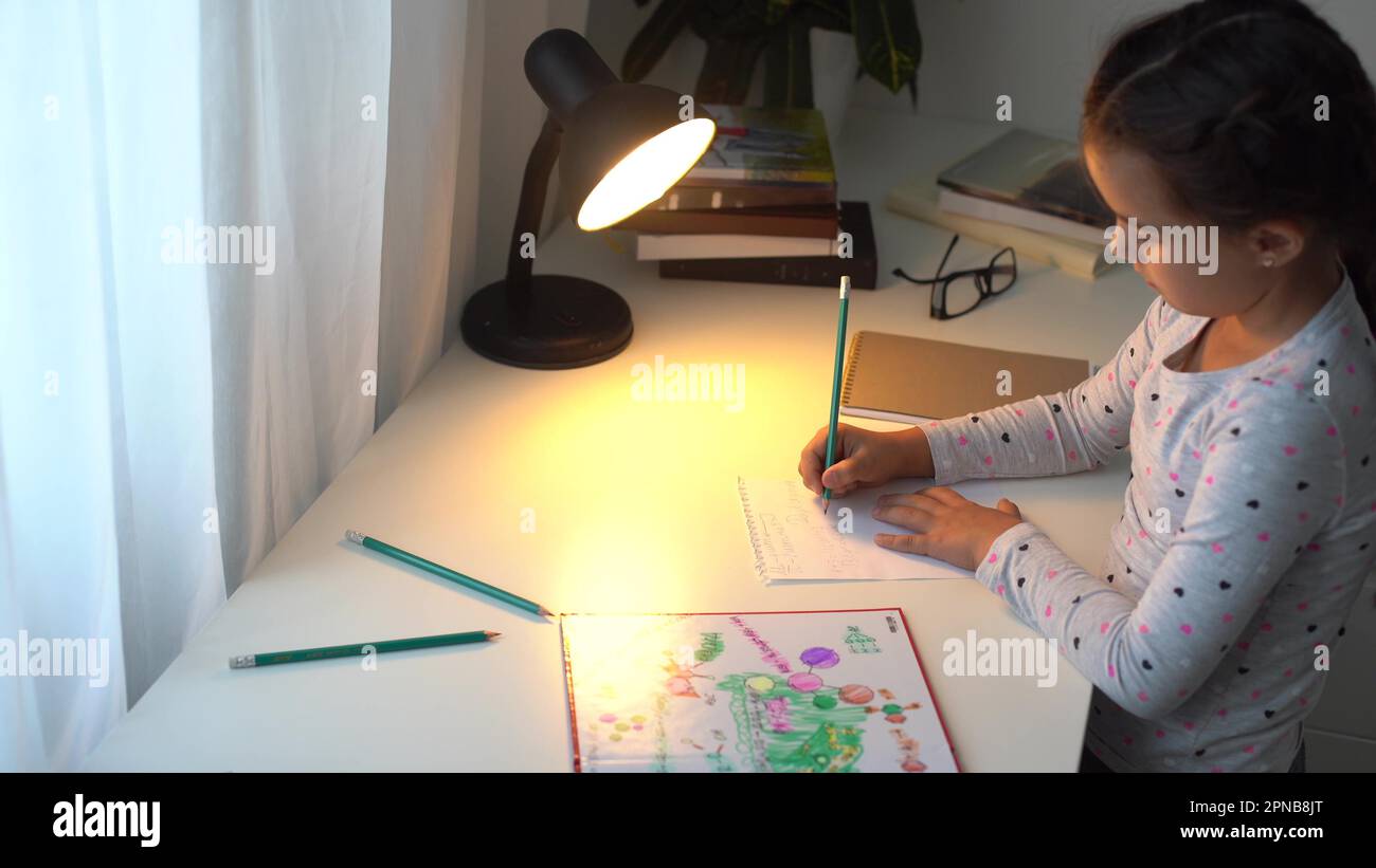 Cute smart primary school child girl learning writing doing math ...