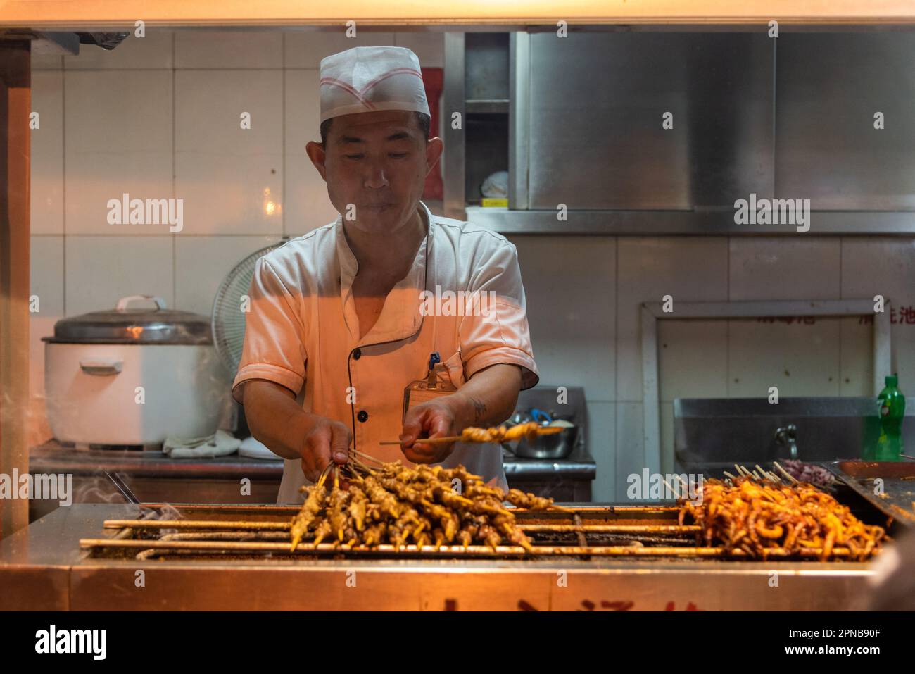 Chinese chef cooking traditional on the snack street in Beijing China ...