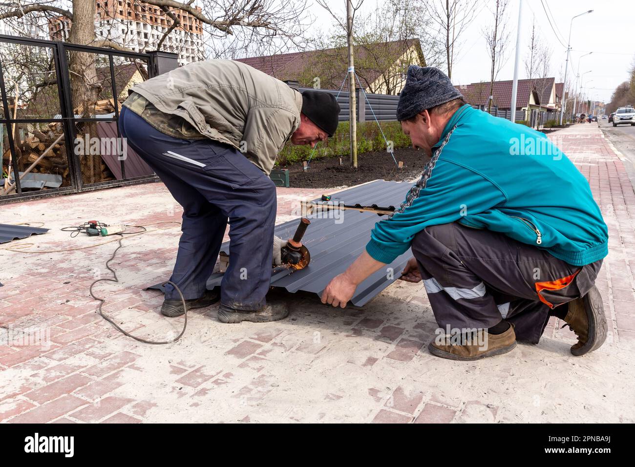 Bucha, Ukraine. 17th Apr, 2023. Men cut a fence as renovated ...