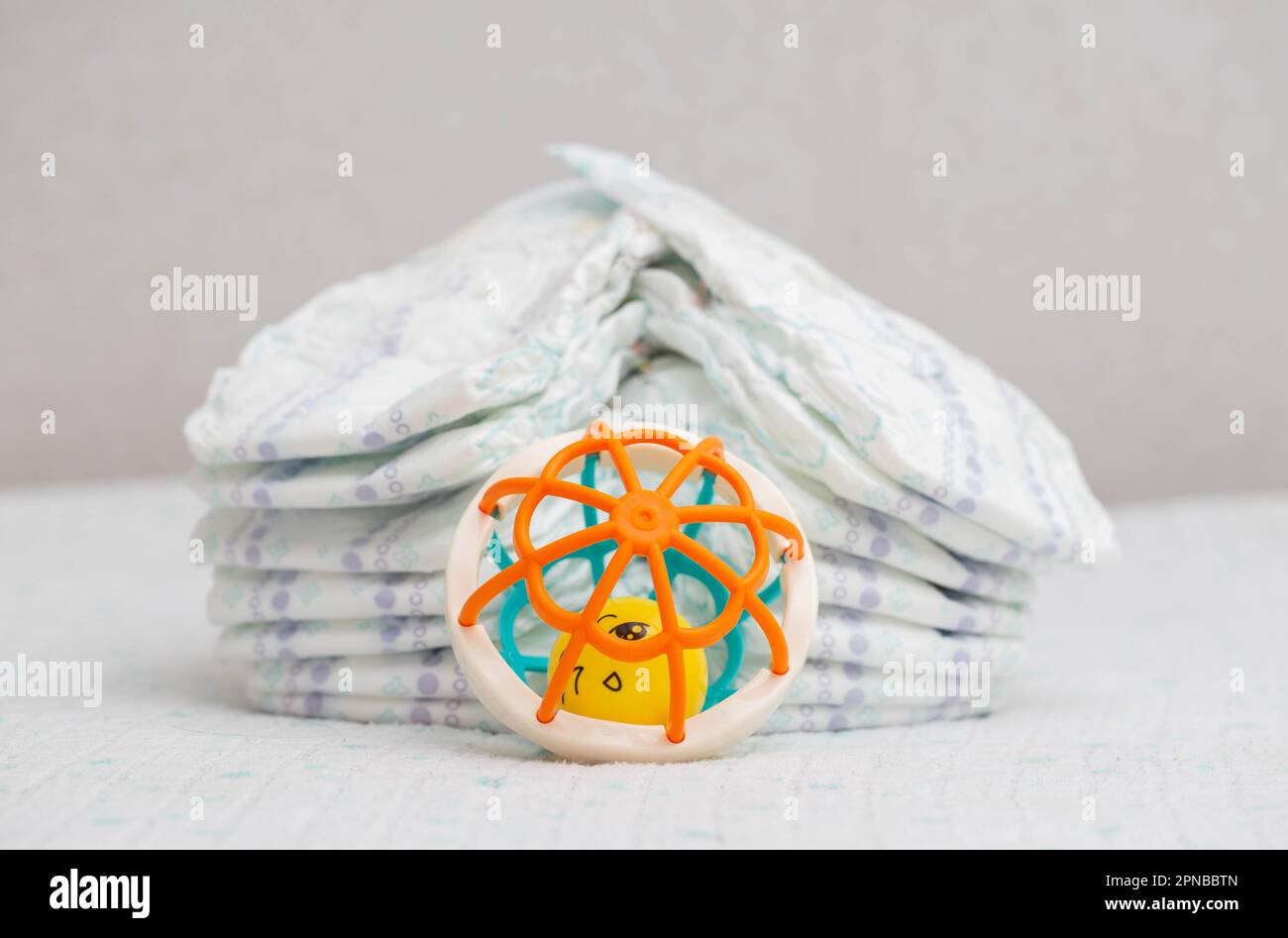 Baby toy on the background of a stack of baby diapers, close-up Stock ...