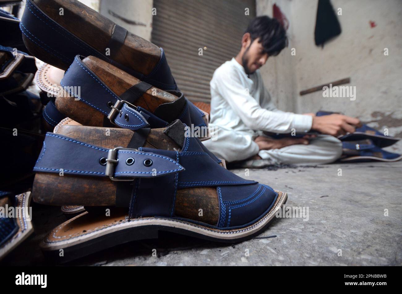 Peshawar, Pakistan. 17th Apr, 2023. A Pakistani cobbler makes ...