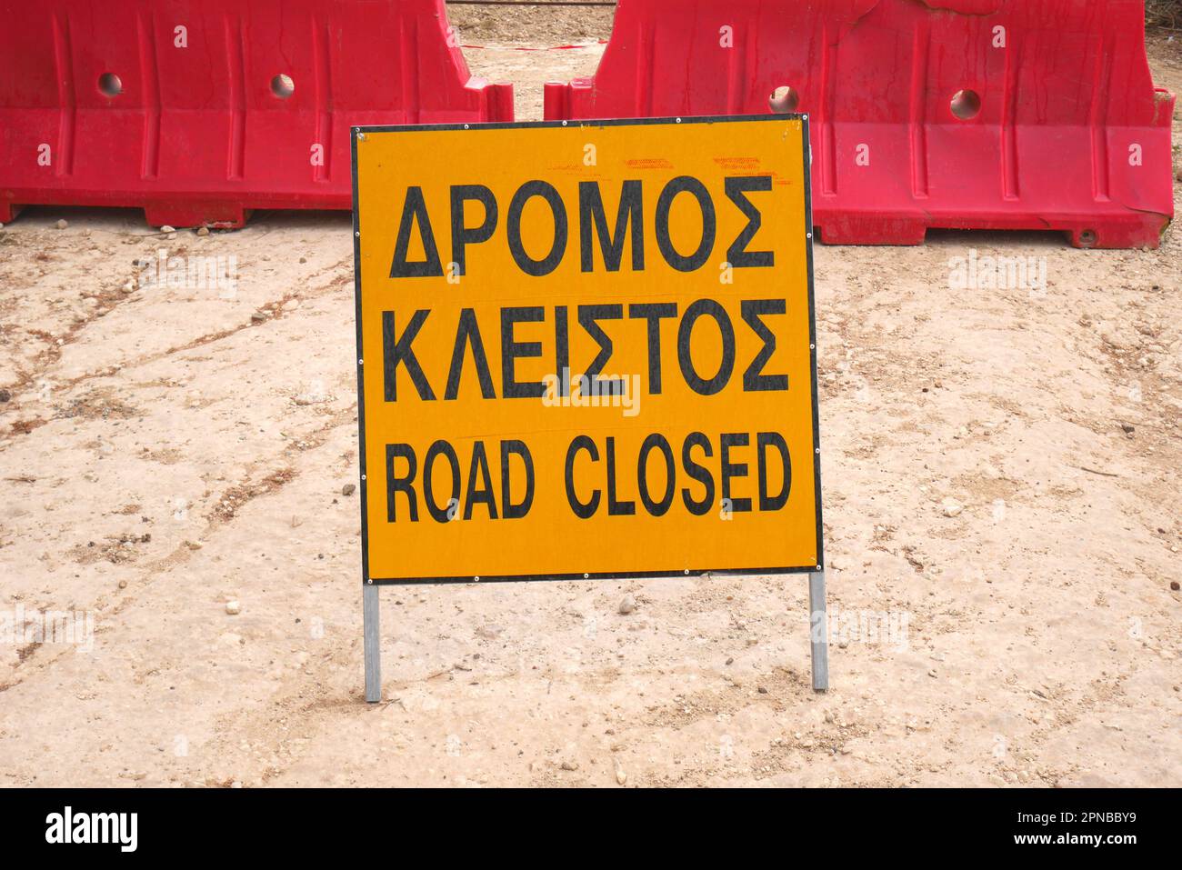 Yellow sign in English and Greek saying Road Closed, with a barrier ...