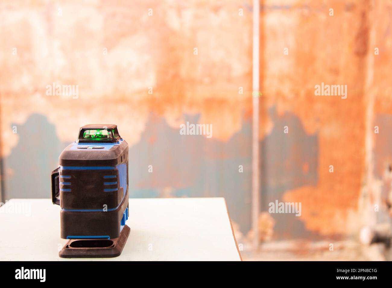 Modern construction laser level against the background of a wall with a ...