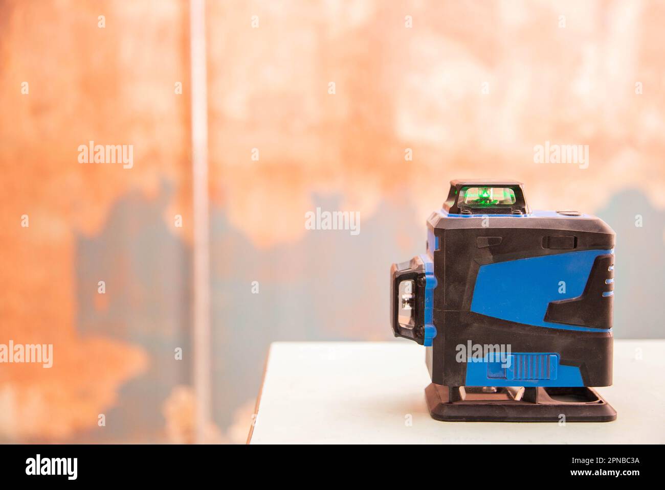 Modern construction laser level against the background of a wall with a ...